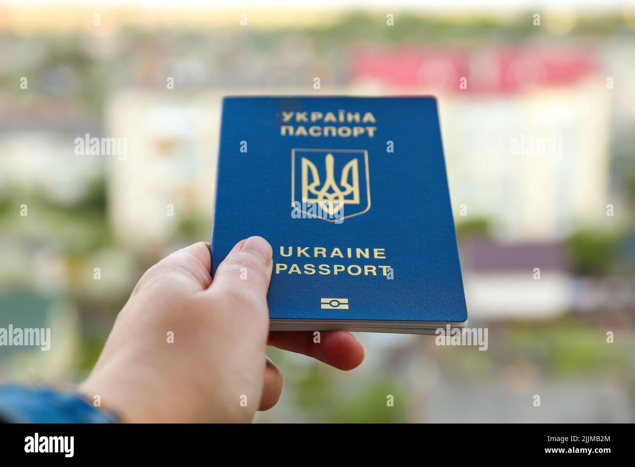 Defocus passport of a citizen of Ukraine in a female hand on a blurred ...