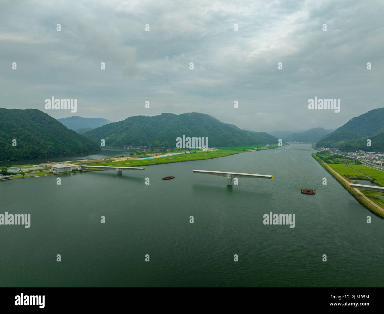 Unfinished roadway on bridge under construction over river in mountain ...