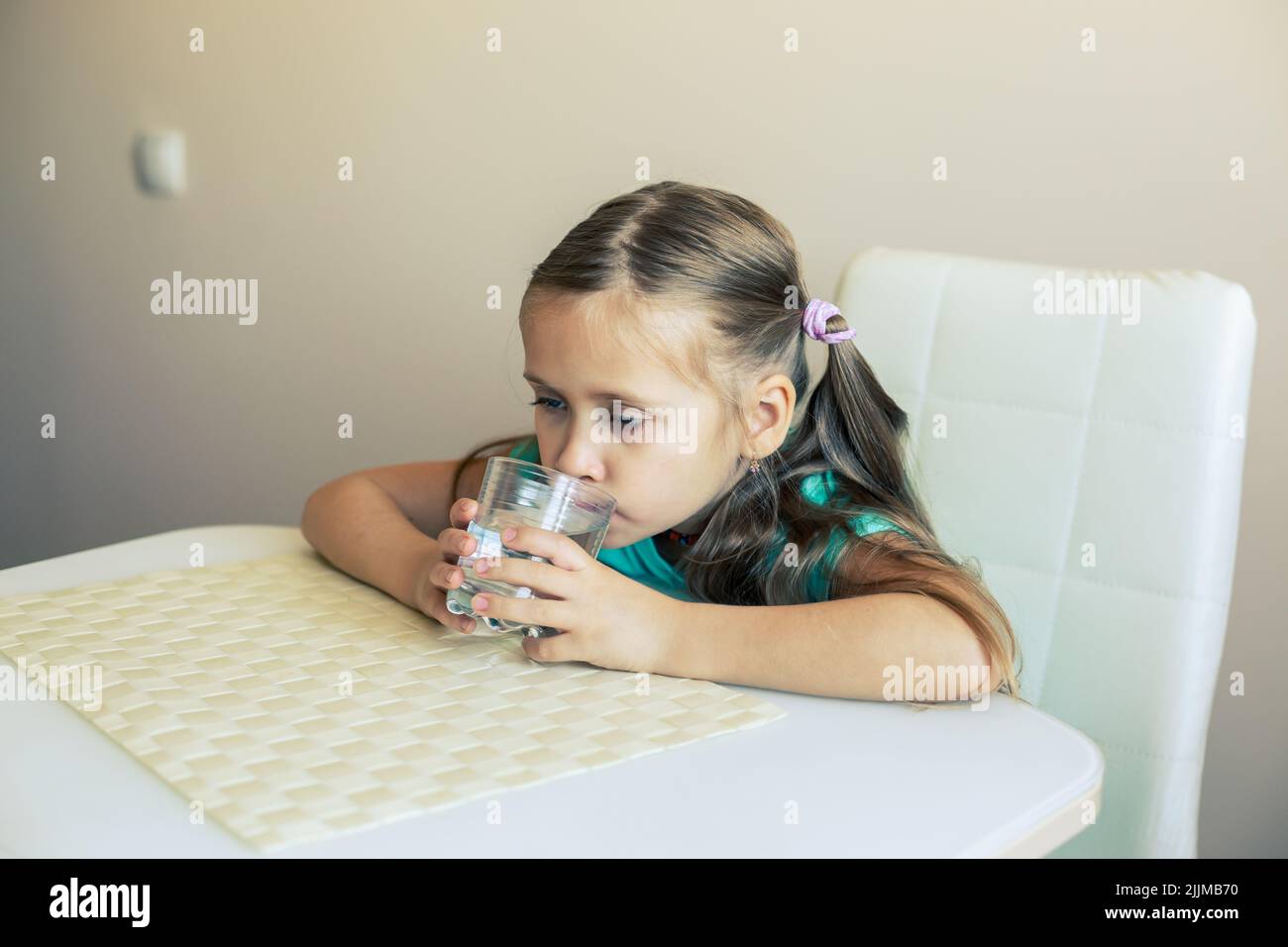 Beautiful little girl drinks clean water from a transparent glass Stock Photo - Alamy