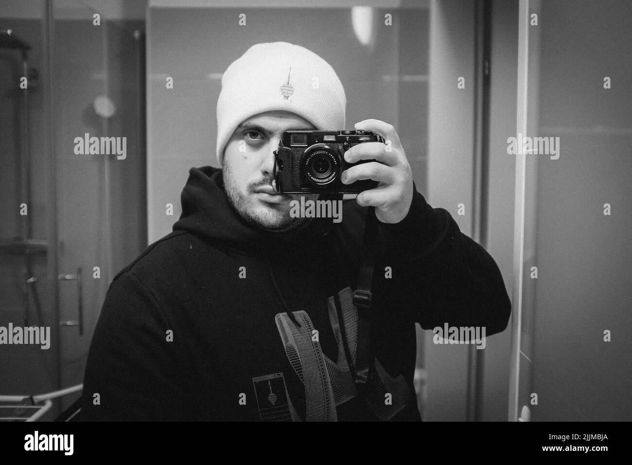 A grayscale shot of a man taking a picture with rangefinder camera in ...