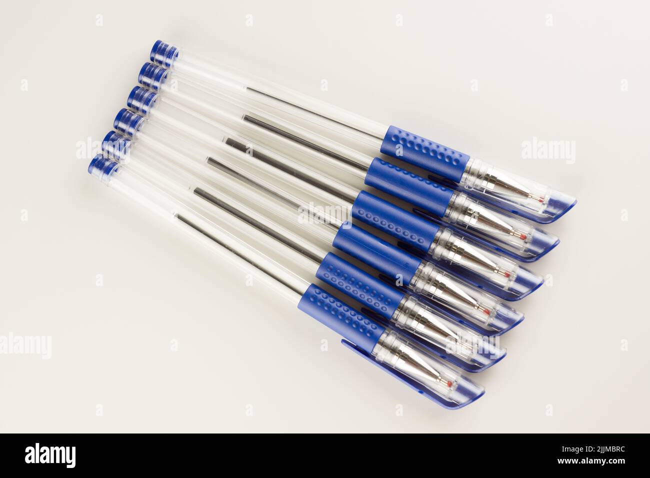 set of blue ballpoint pens lined up hardly on a white background Stock ...