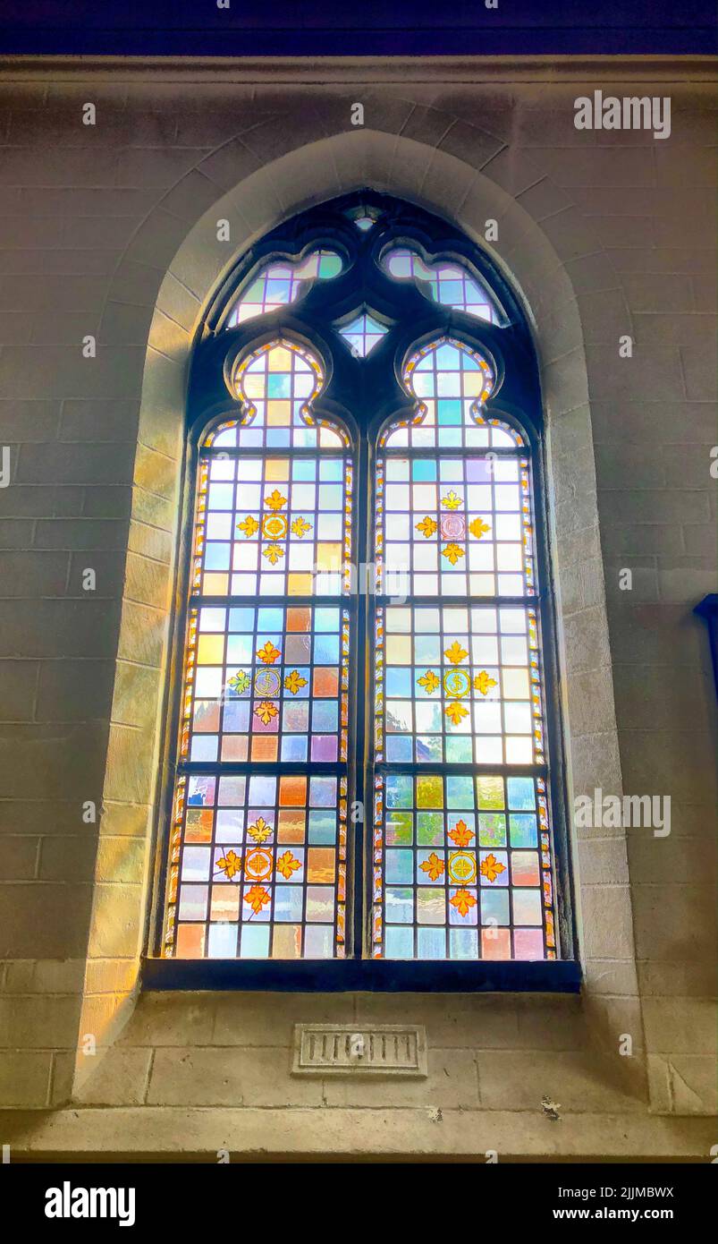 Old arched church window, with mullioned and leaded colored glass, set ...