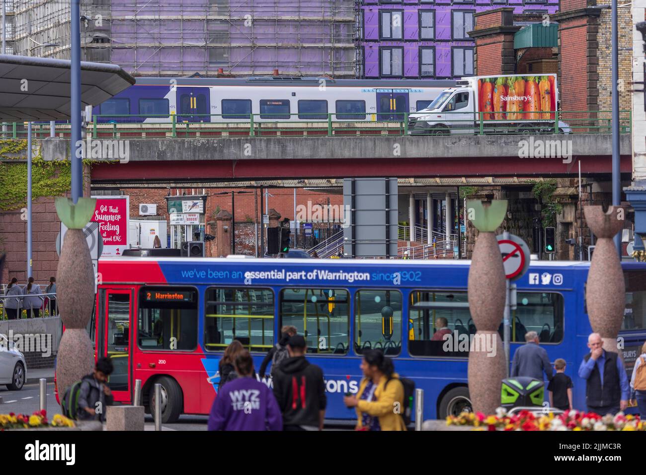 Busy town centre in Warrington with the railway train arriving at ...
