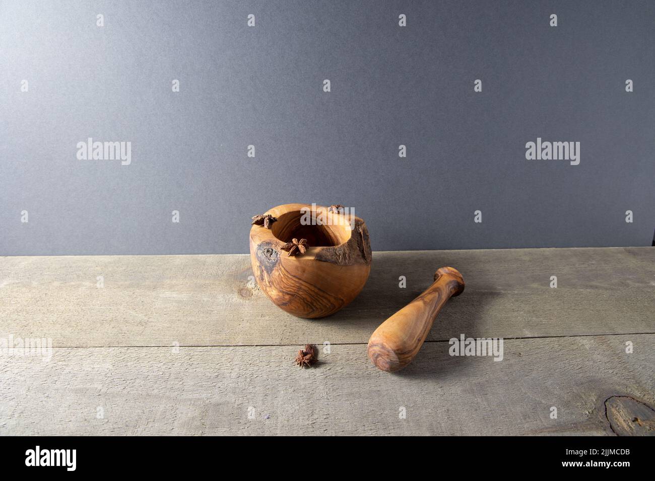 A wooden mortar and pestle on a table in plain wall background Stock ...