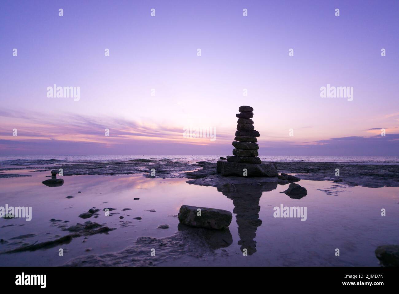 A beautiful view of a stack of balanced pebbles on the seashore at ...