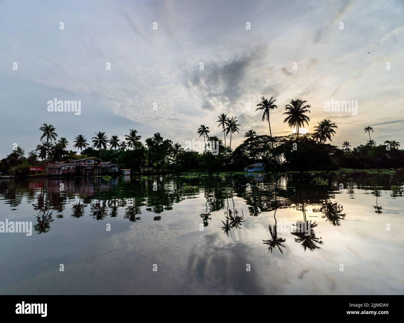 A scenic view of palm trees reflected on the calm water surface during ...