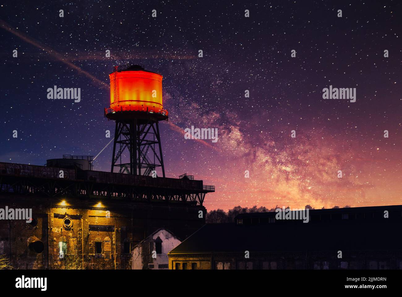A water tower with red lights during night under the beautiful starry ...