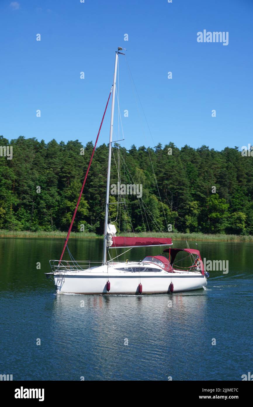Sailboat swimming with en engine - side view Stock Photo - Alamy