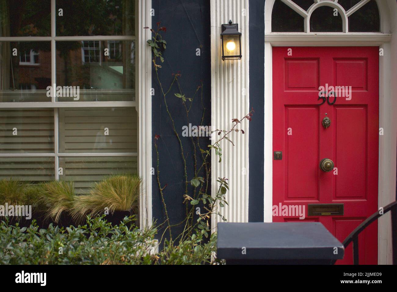 Bright Red door with front garden and window Stock Photo - Alamy
