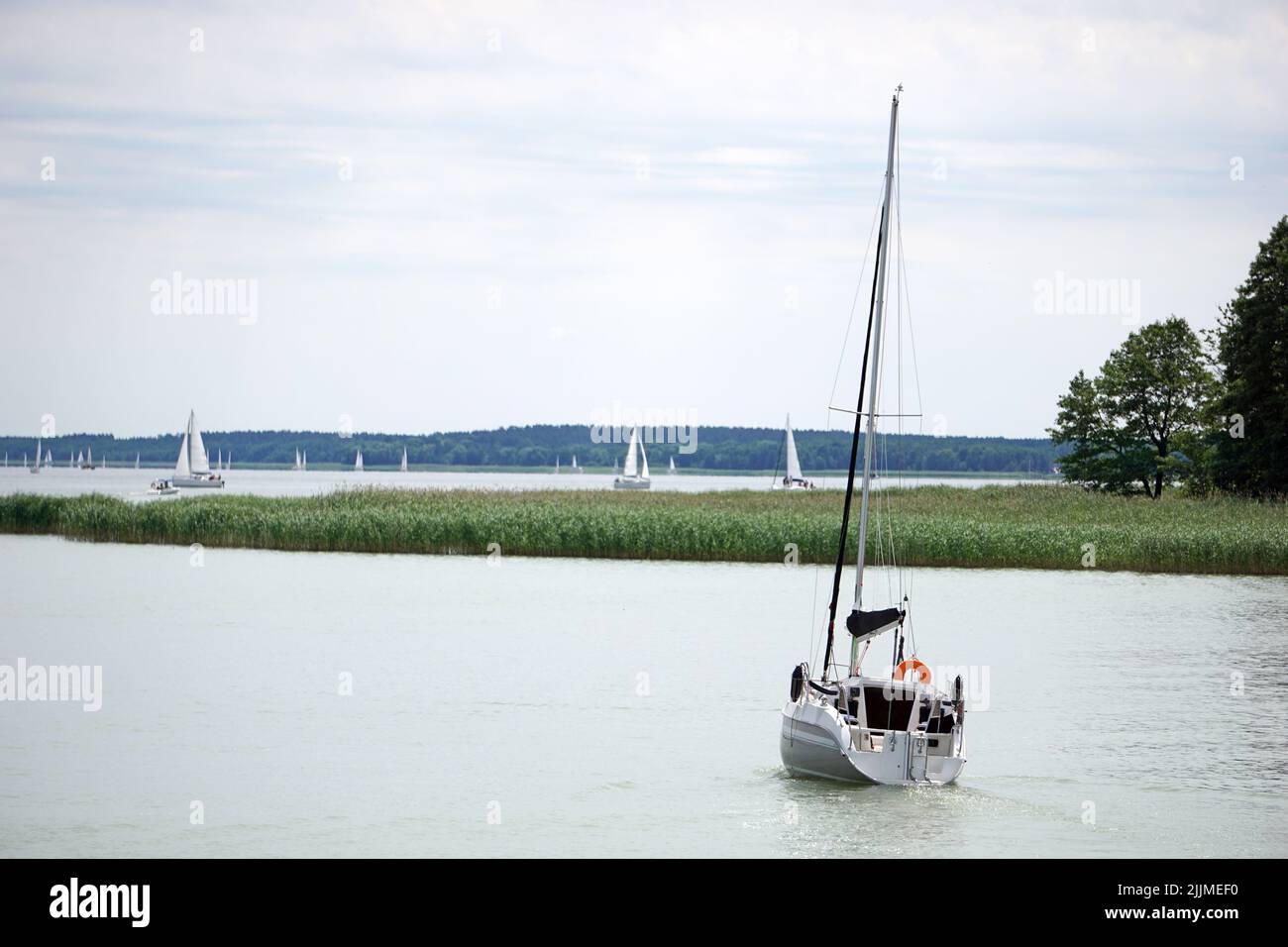Sailboat swimming with en engine - back view Stock Photo - Alamy