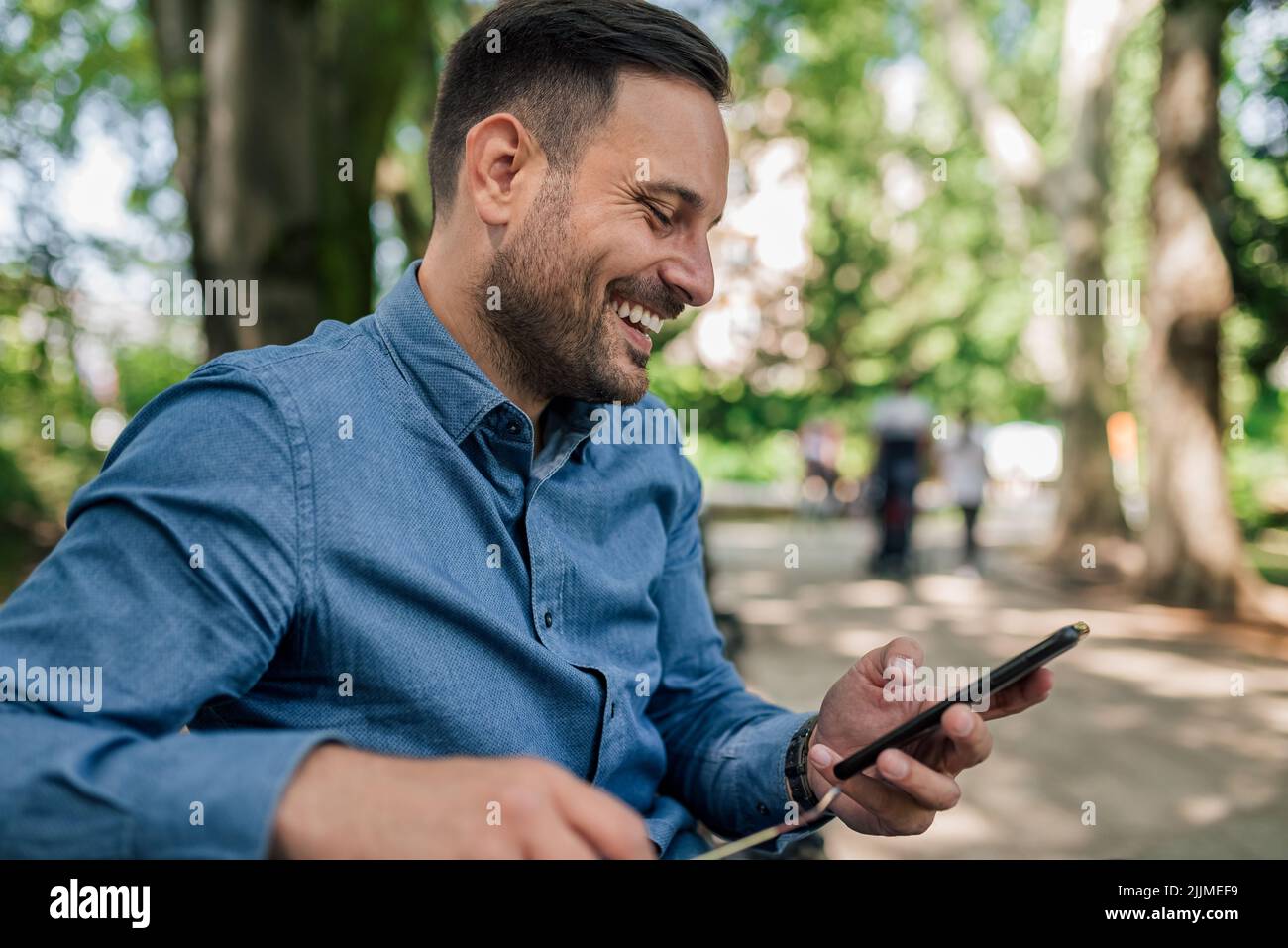 Cheerful male professional socializing on smart phone. Young smiling ...