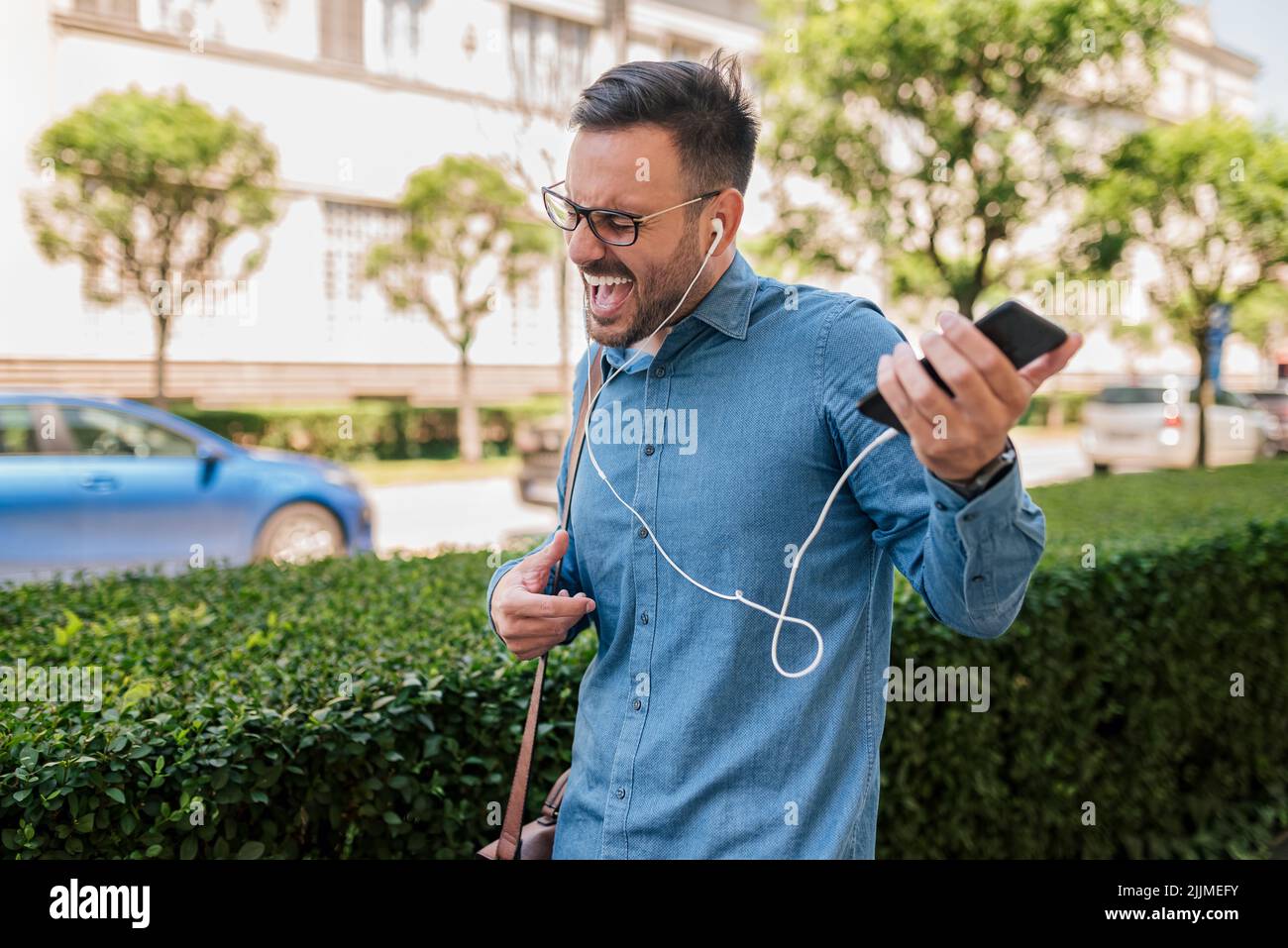 Professional wearing headphones shouting and singing while gesturing ...