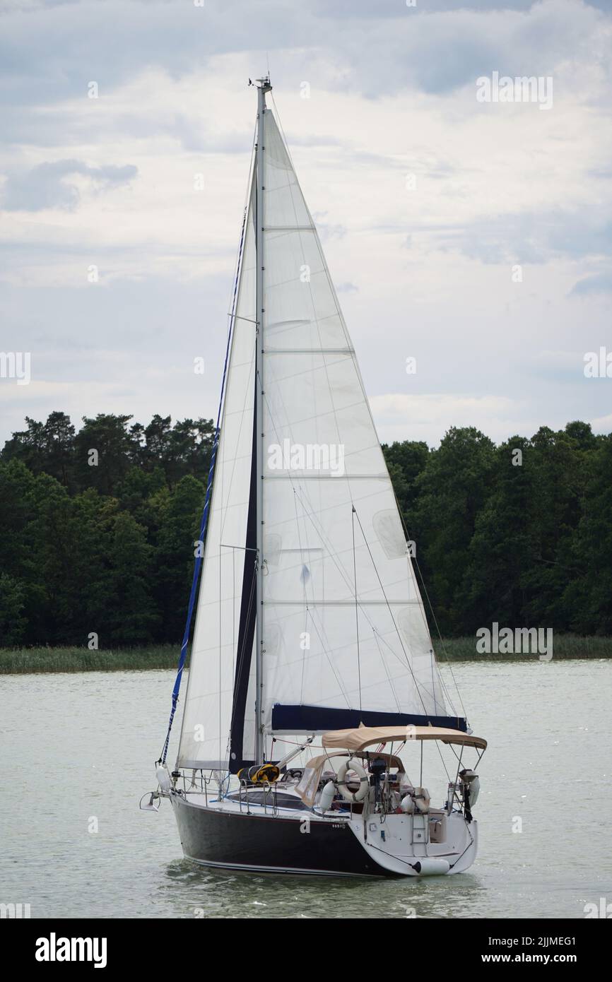 Sailboat swimming on a lake - back view Stock Photo - Alamy