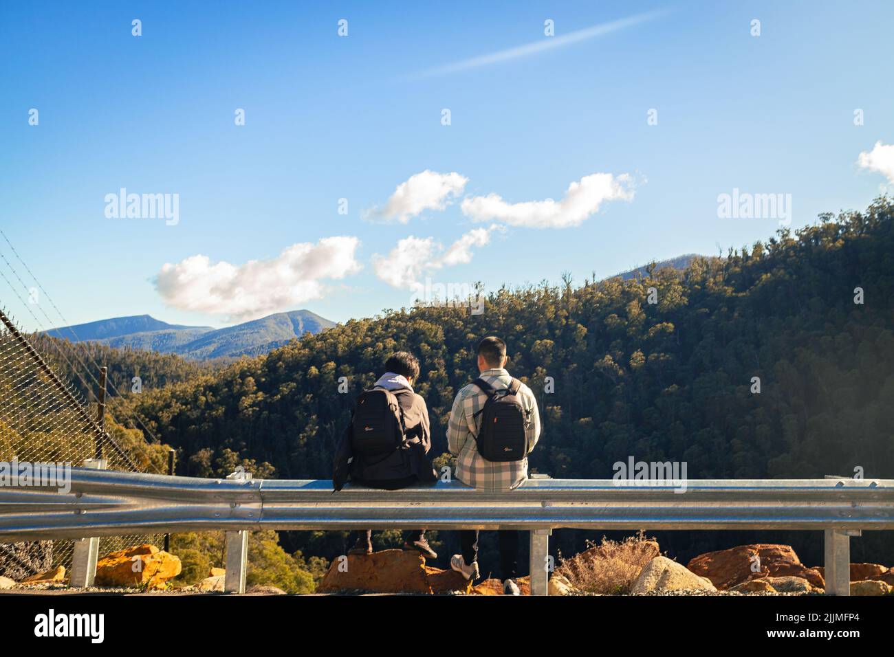 A back shot of two people catching up looking at the mountain view with ...