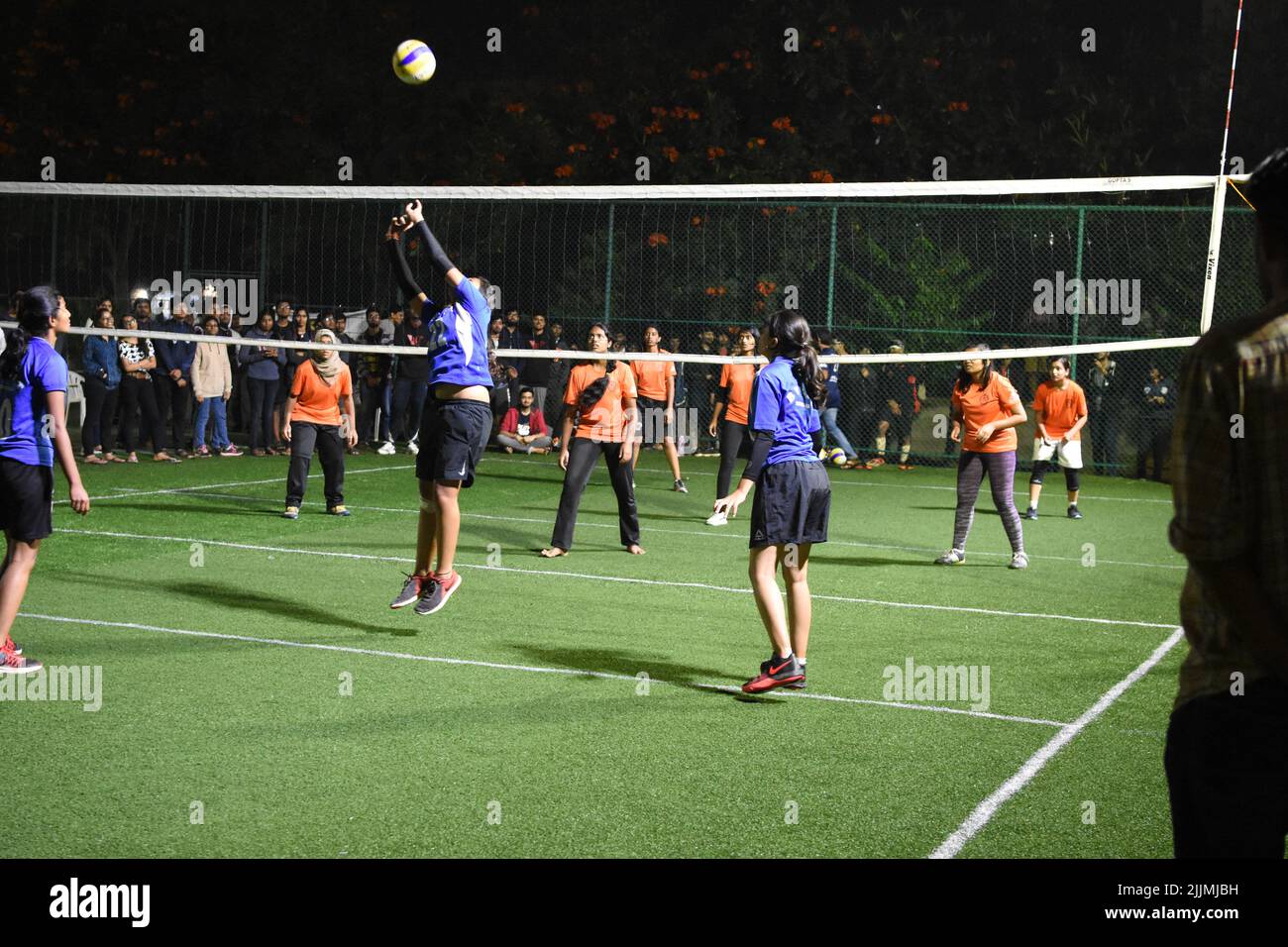 A closeup of a Collage Volleyball match under the lights Stock Photo ...