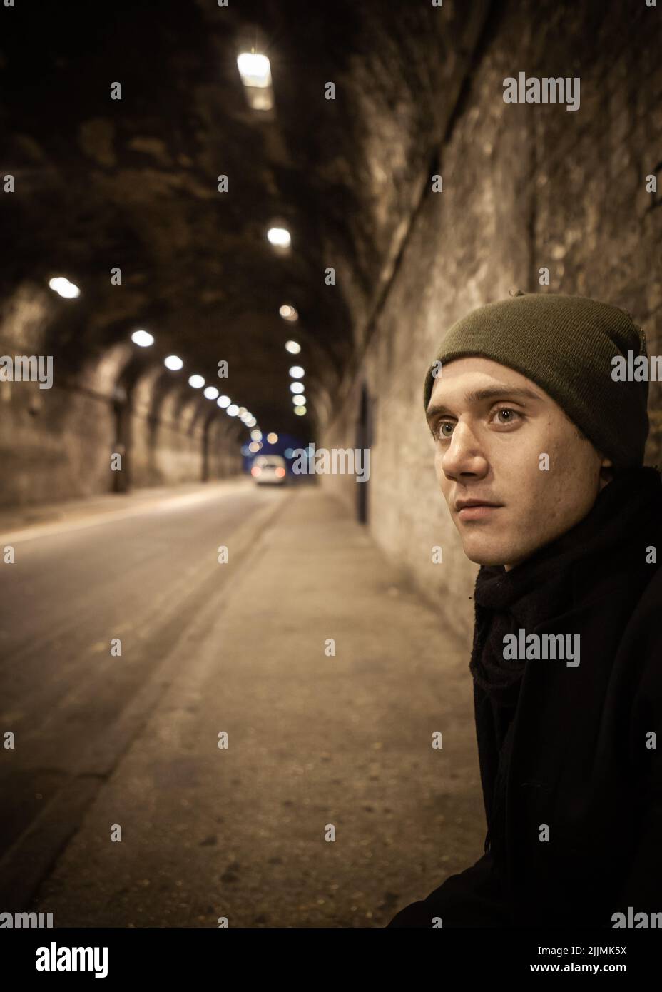 Urban Anxiety. A solitary man waits anxiously in a late night urban ...