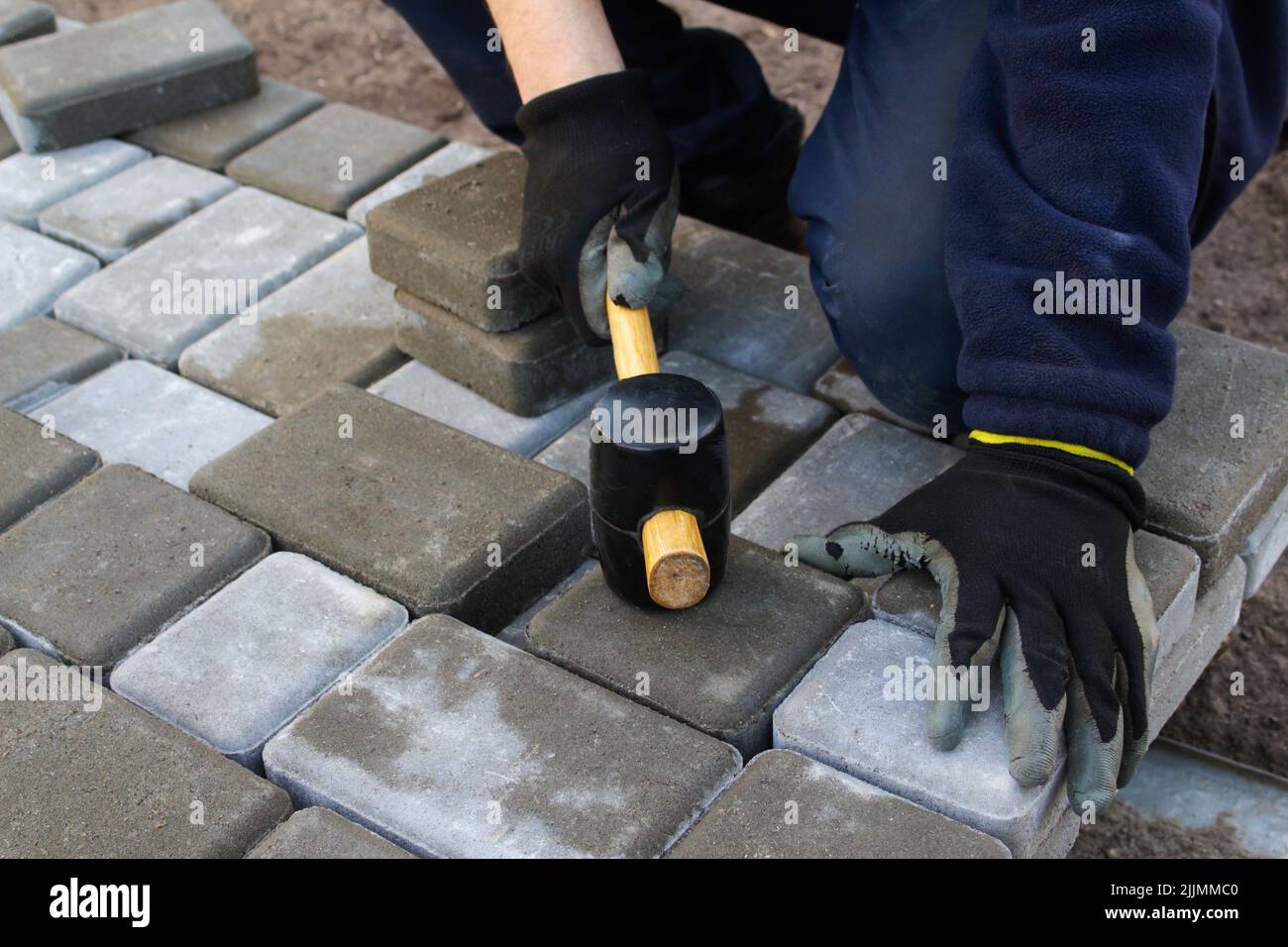 Defocus paver master. Man lays paving stones in layers. Garden brick ...