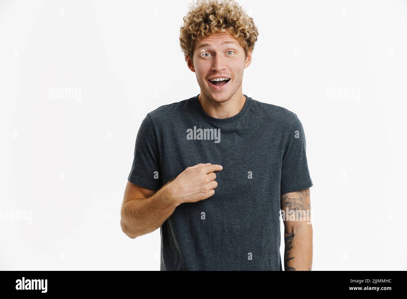 Young excited man laughing while pointing finger at himself isolated ...