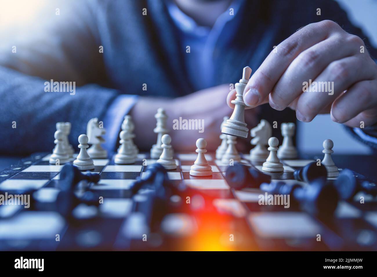 A man holding a king chess piece while playing a chess game - stategy ...