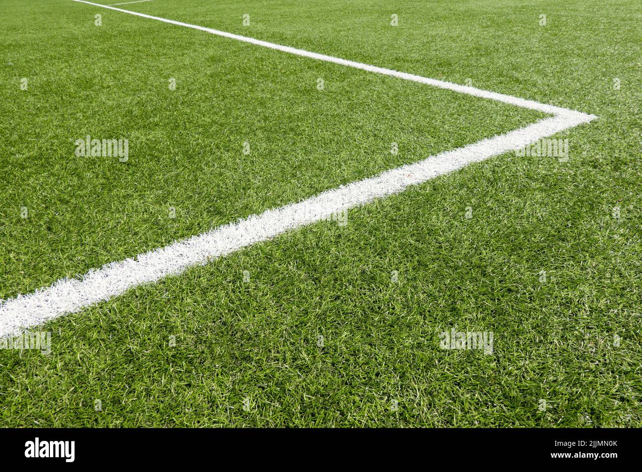 Green synthetic artificial grass soccer sports field with white corner ...