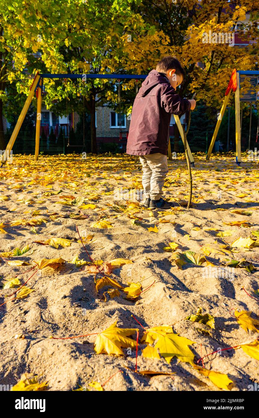 A vertical shot of a Caucasian boy playing on the playground in Poznan ...