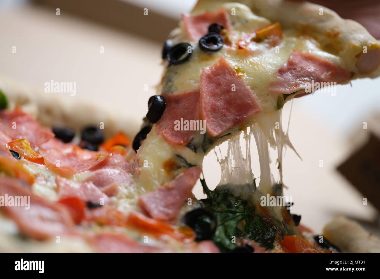 Hand holds pizza cheese ham and olives box Stock Photo - Alamy