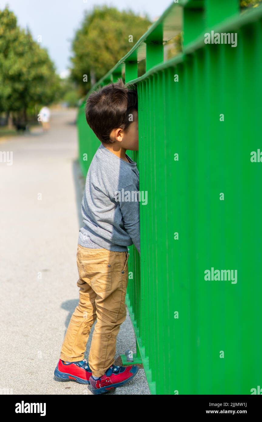 Boy standing behind wall hi-res stock photography and images - Alamy