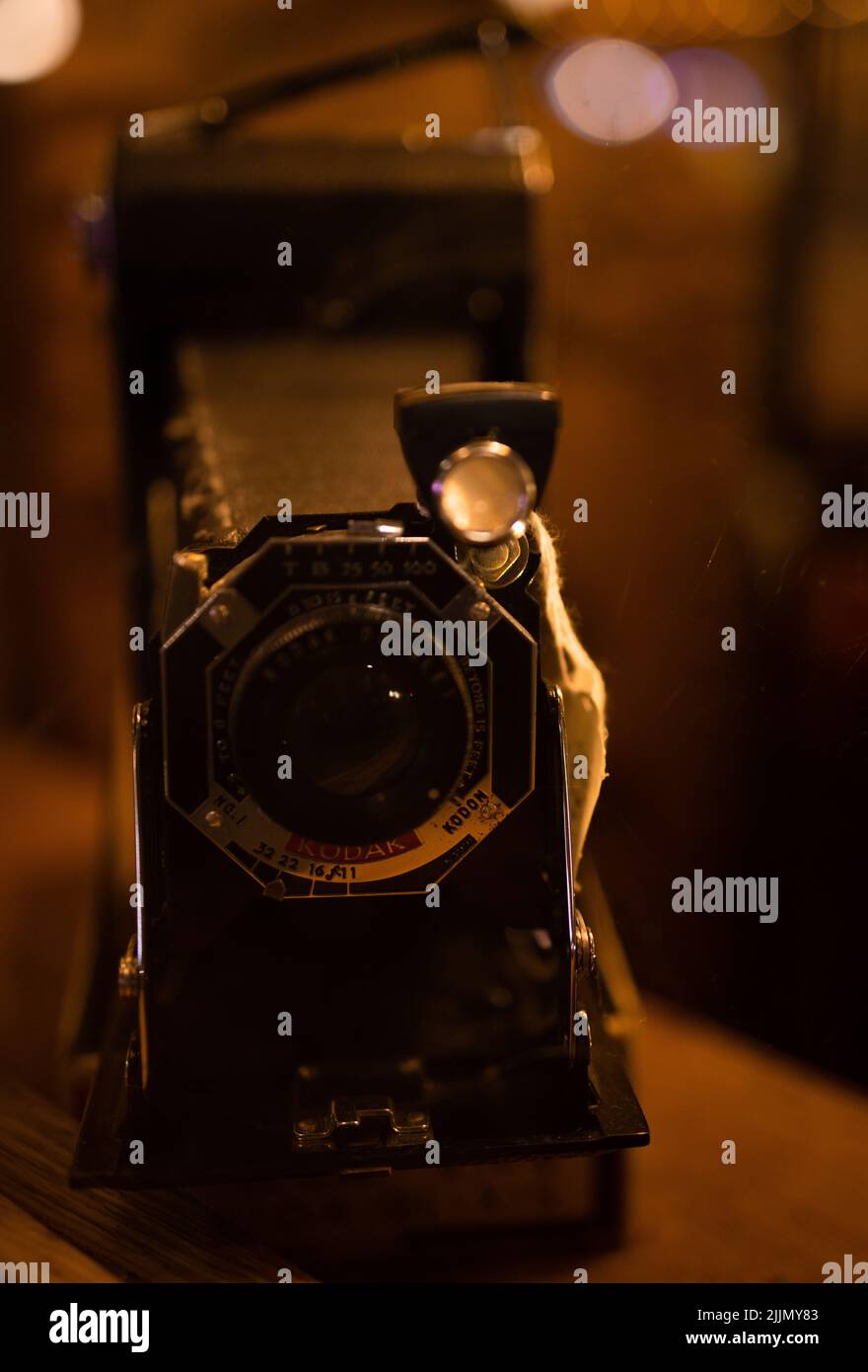 A vertical shot of a vintage camera in a blurry warm background Stock ...
