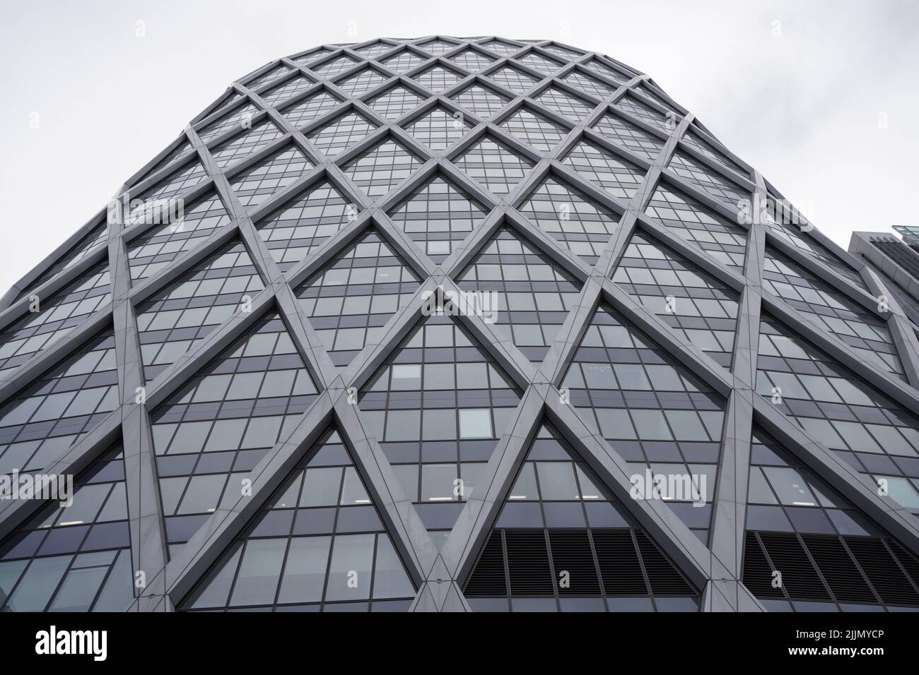 A low angle view of a symmetrical tall modern building with glass ...
