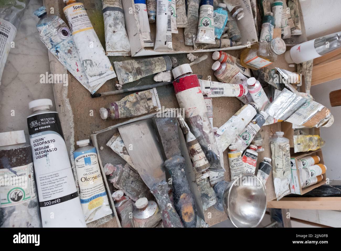 A top view of dozens of used artists paint tubes on a table Stock Photo ...