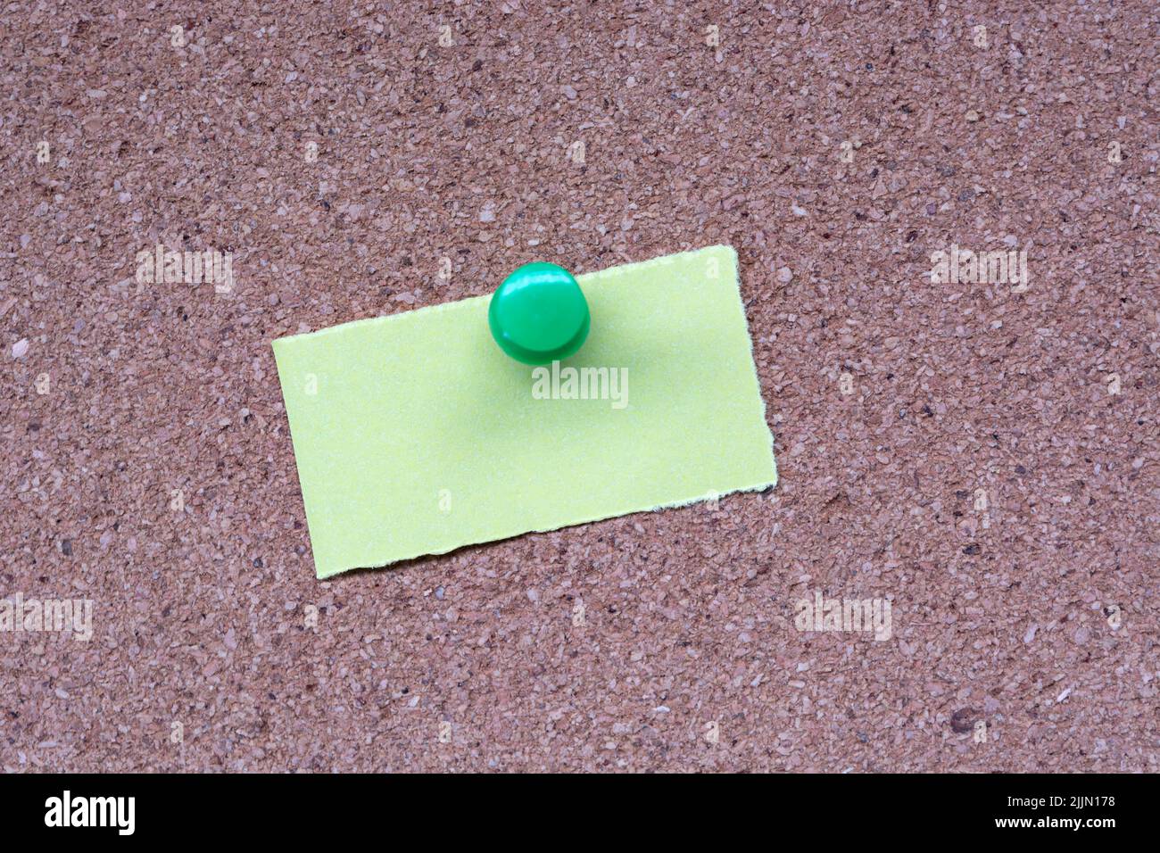 Yellow stick note and pinned to a cork notice board. Copy space ...