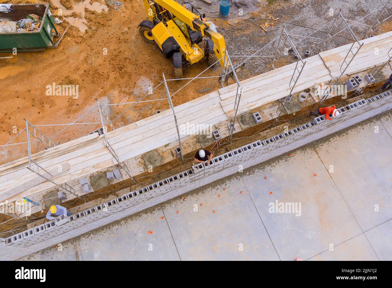 In a construction site scaffolding where masonry blocks are being laid ...