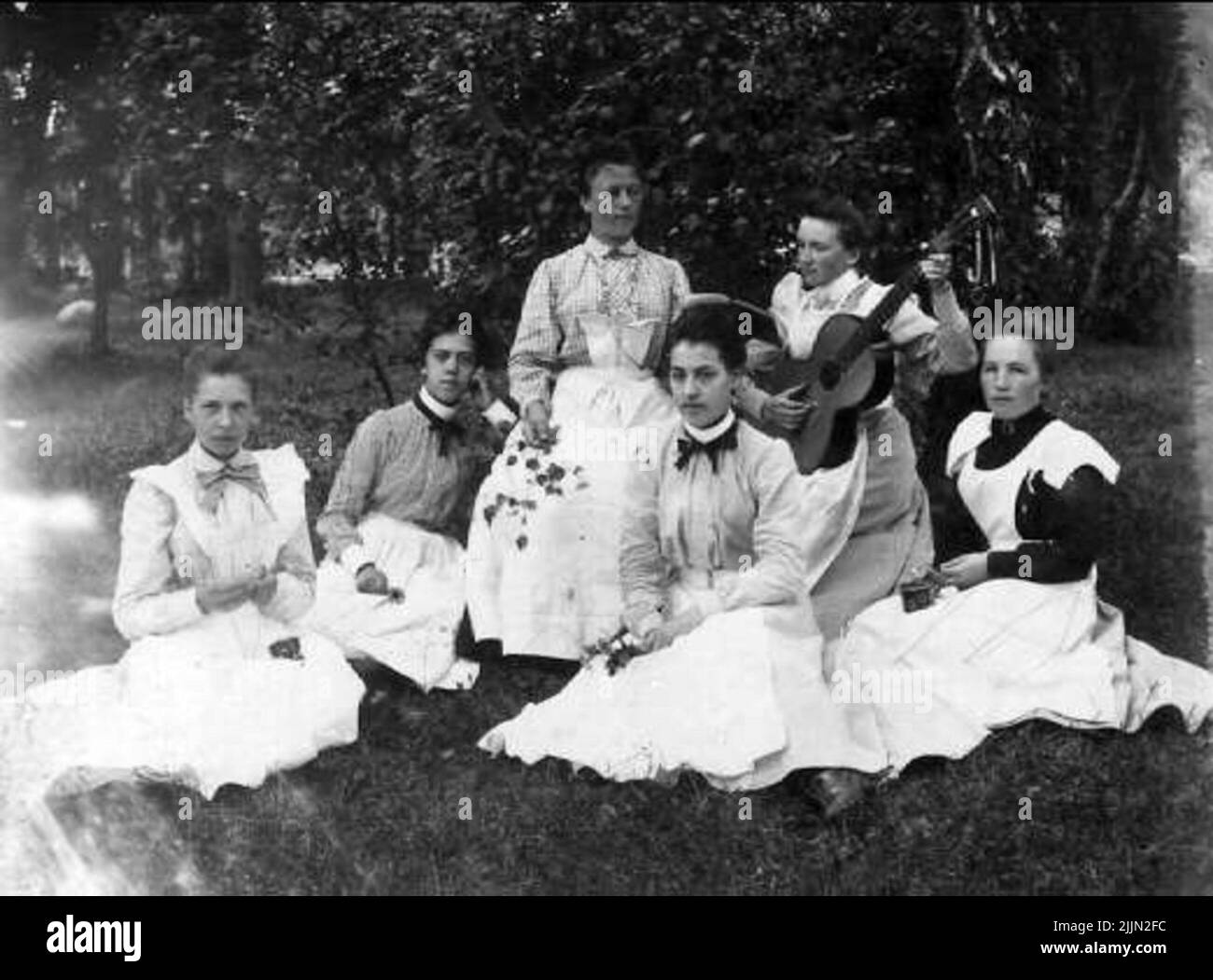 Group photo of six ladies sitting in the green grass around the turn of ...
