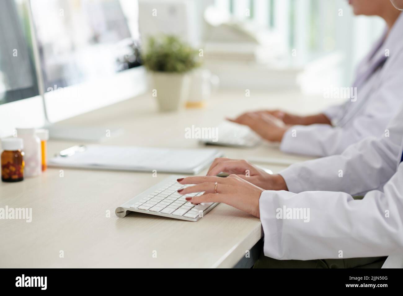 Close-up image of doctor entering patients data in form on computer at ...