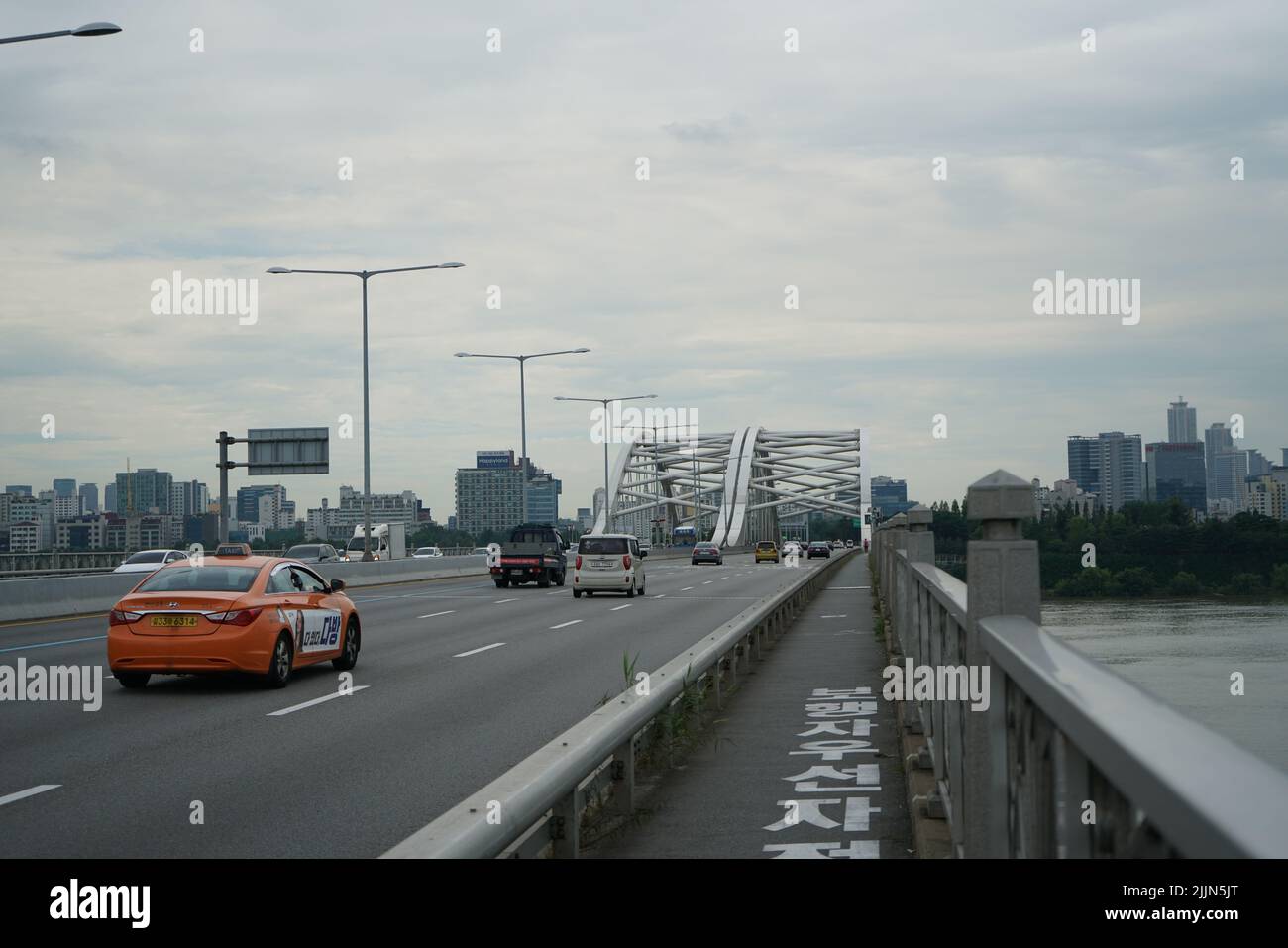 A closeup of cars driving down the road on a bridge Stock Photo - Alamy