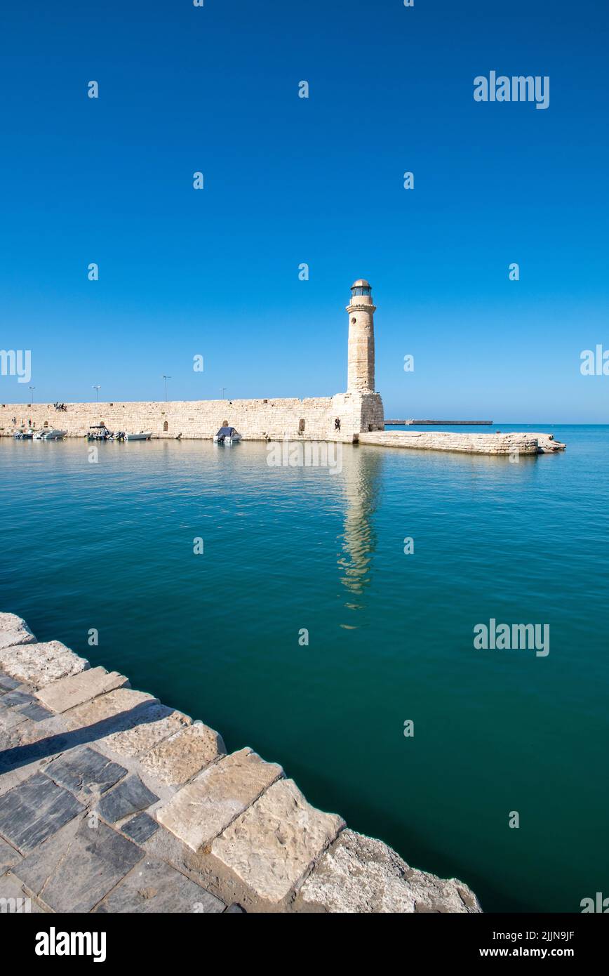 historic stone lighthouse at the entrance to rethymnon harbour on the ...