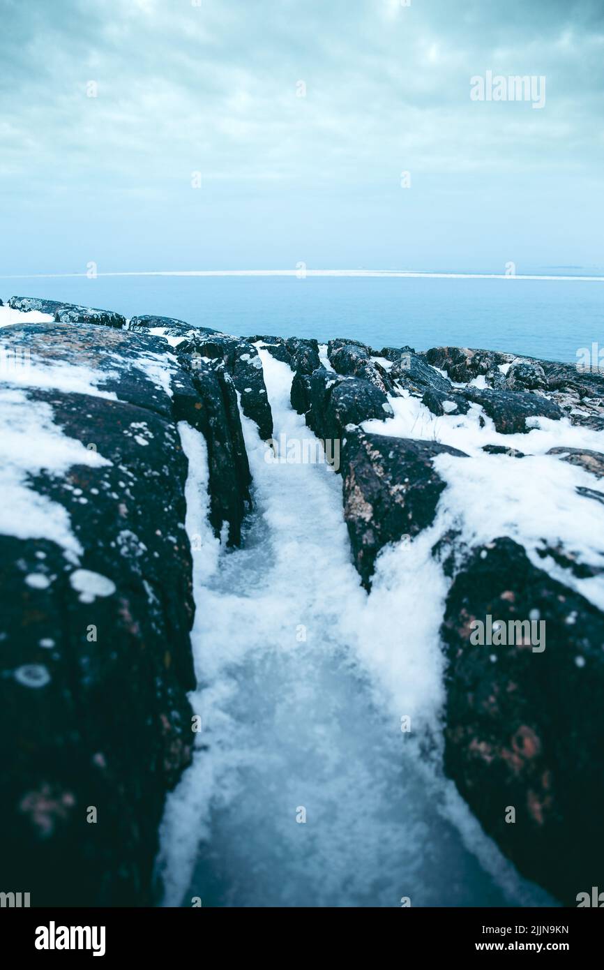 A close-up shot of frozen rocks under the cloudy skies Stock Photo - Alamy