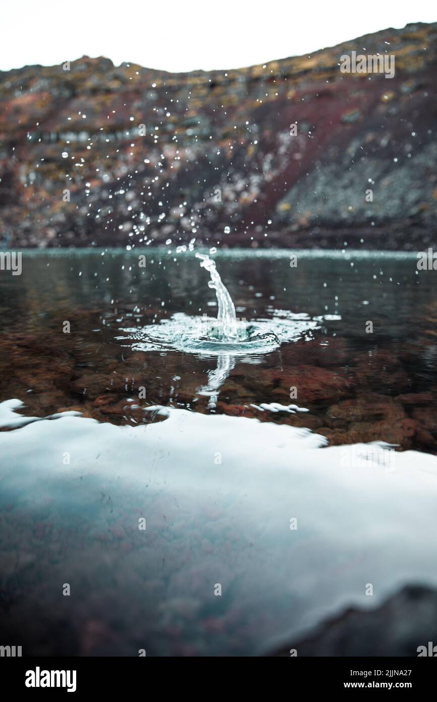 A vertical shot of water splash on a clear water Stock Photo - Alamy