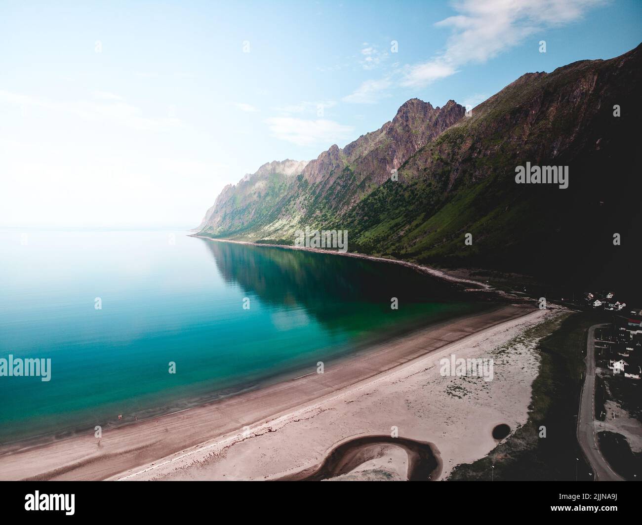 The beautiful beach of Senja island with reflection of the cliffs seen ...