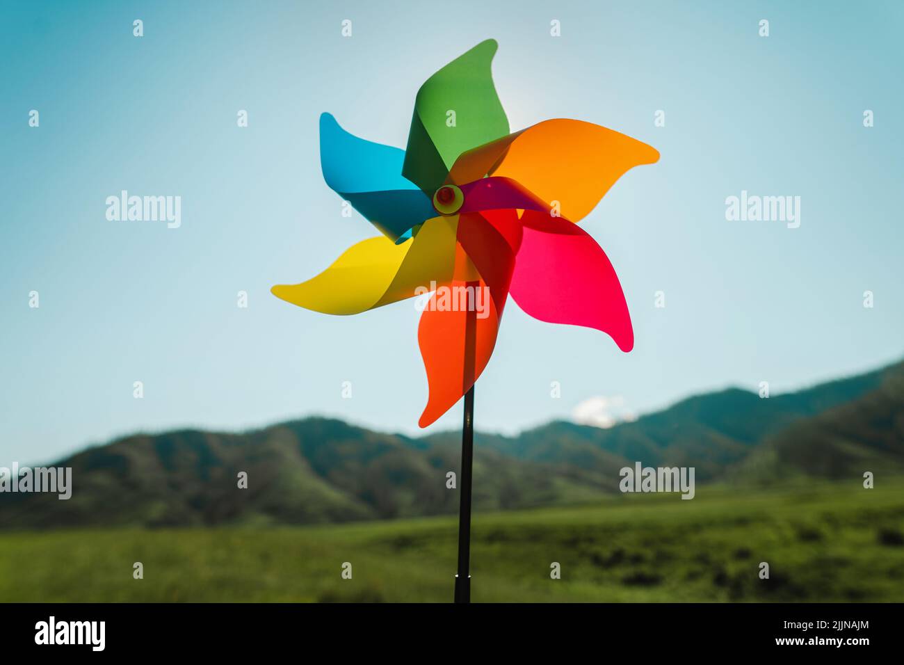 A multi-colored children's windmill, pinwheel in the background of sky ...