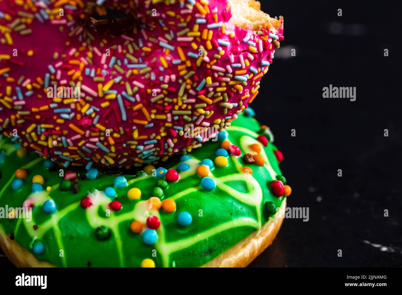 Glazed donuts with sprinkles isolated on a black background Stock Photo ...