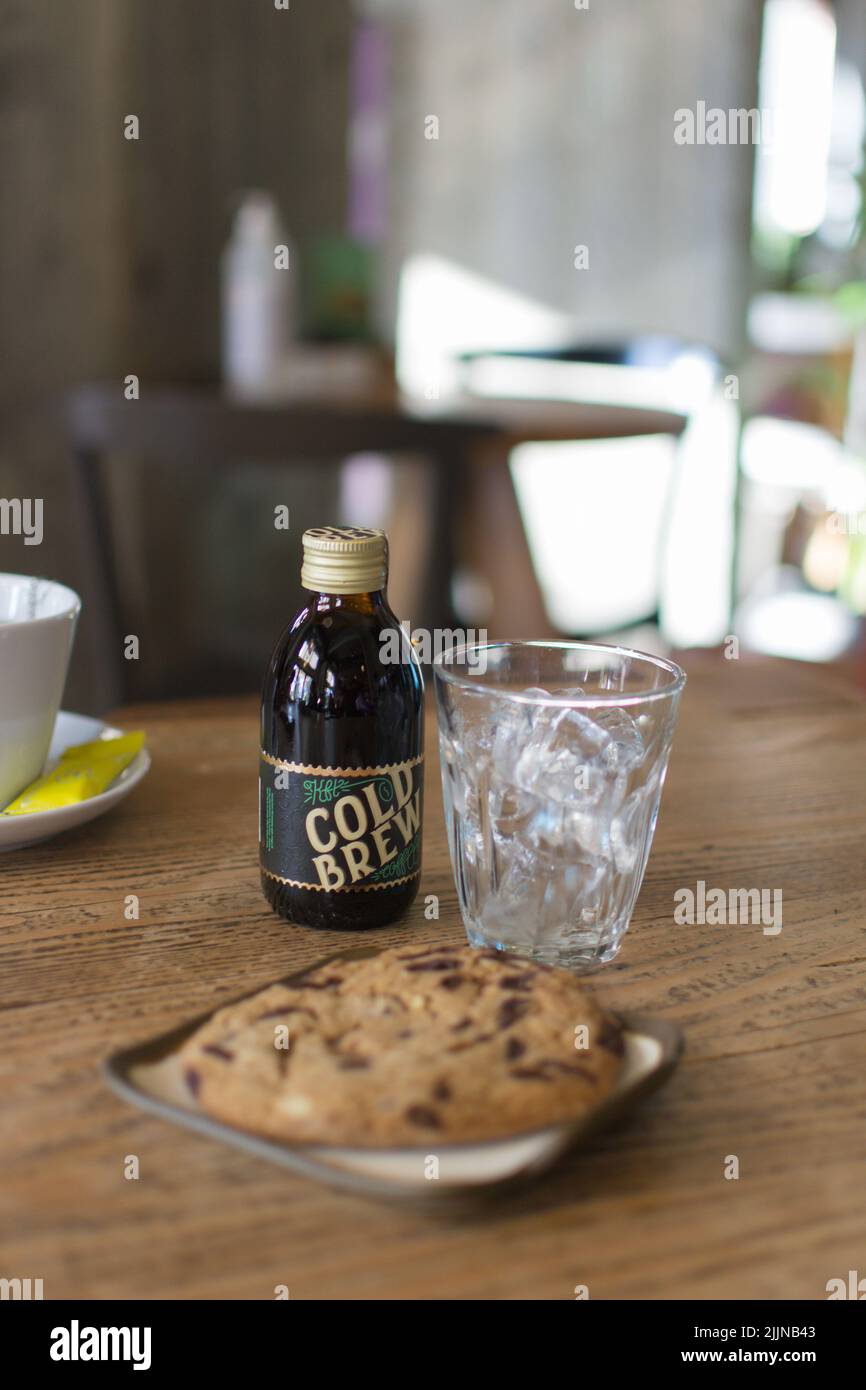 A closeup shot of Cold Brew coffee, cookie and a glass with ice cubes ...