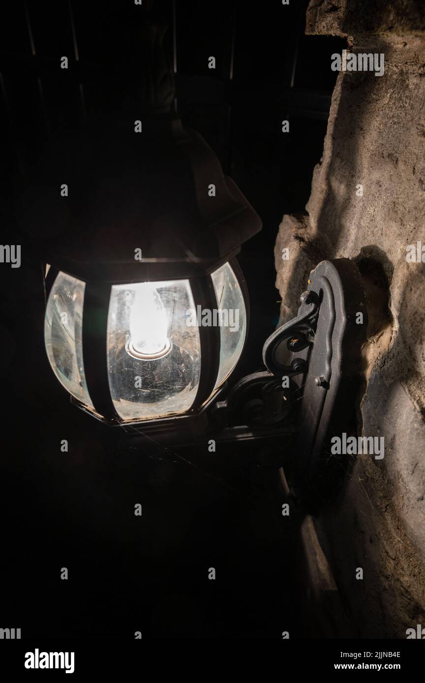 A vertical shot of a lit street lamp Stock Photo - Alamy