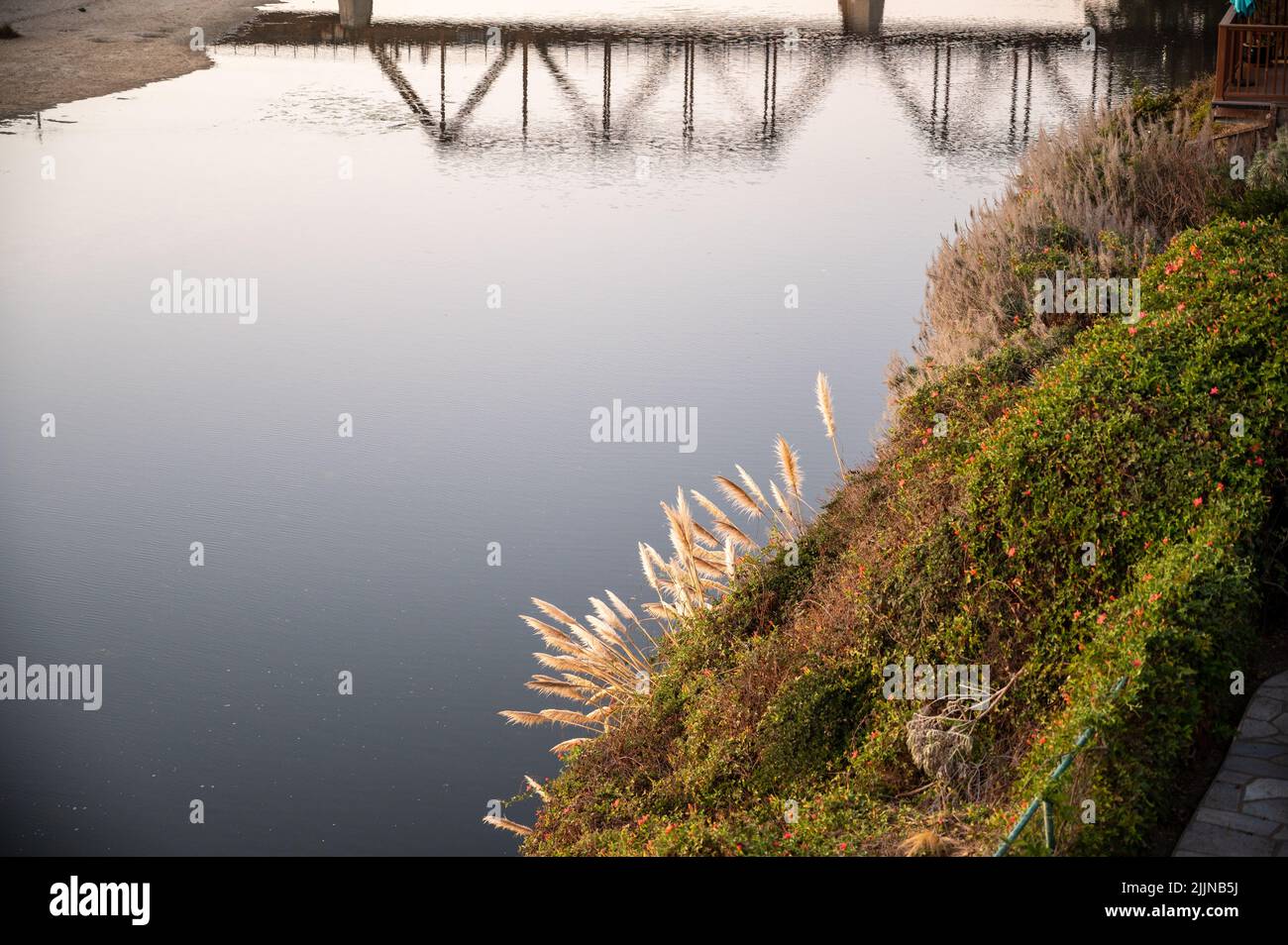 The reflection of a railroad bridge on a river Stock Photo - Alamy