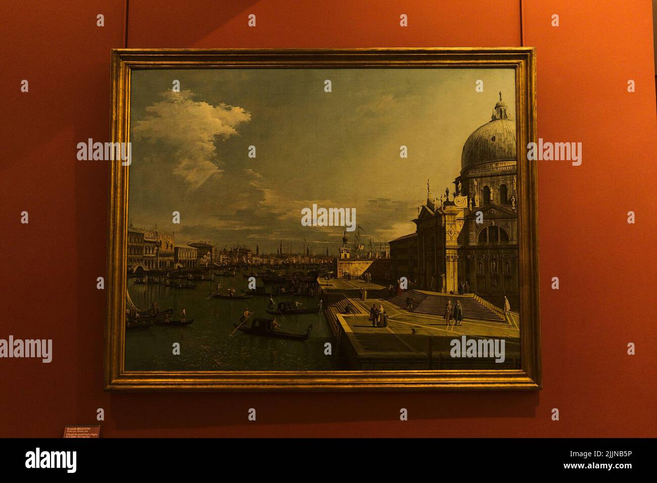 A painting hanging on the red wall of the Louvre museum, Paris, France ...