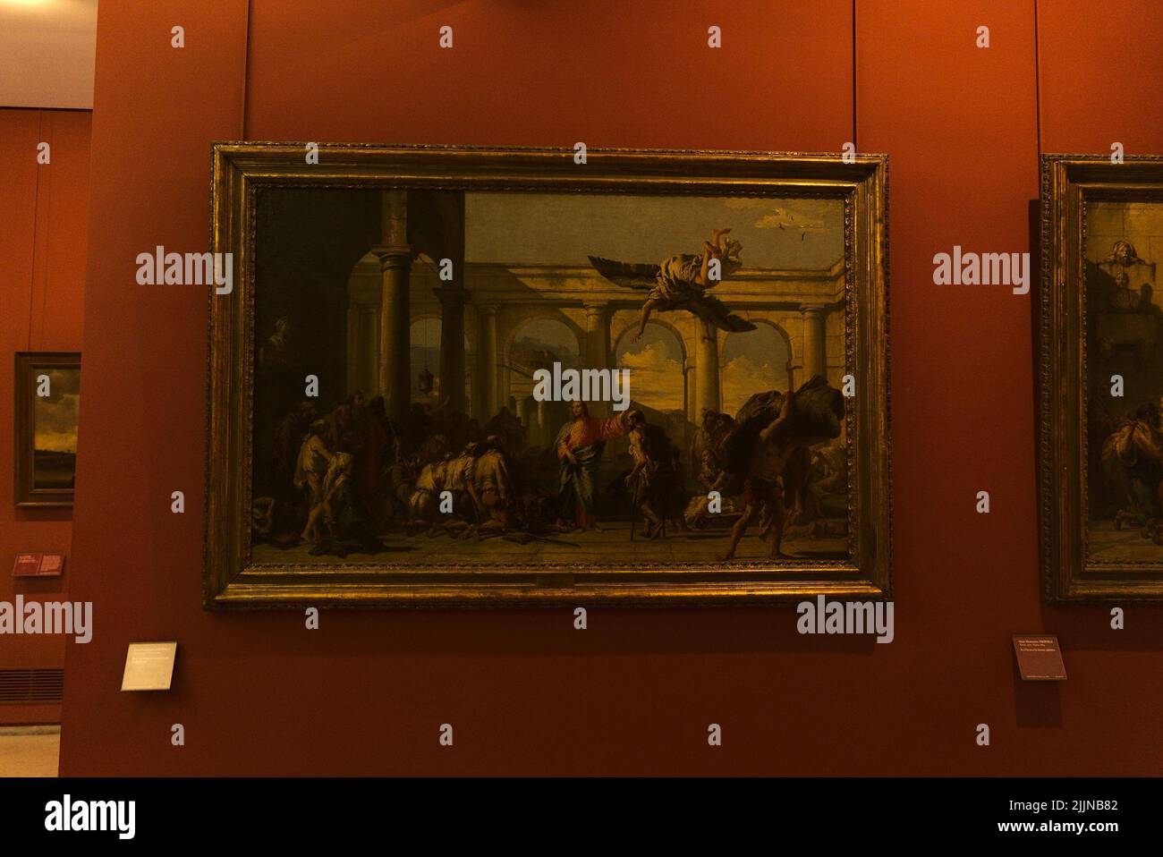 A painting hanging on the red wall of the Louvre museum, Paris, France ...