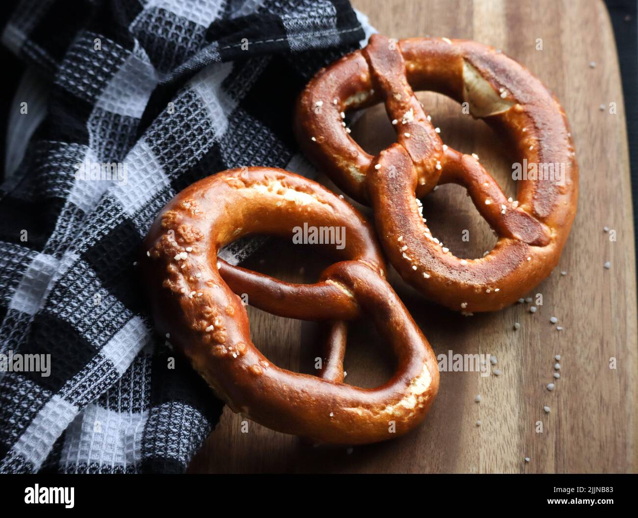 2 pretzels on a wooden board Stock Photo - Alamy
