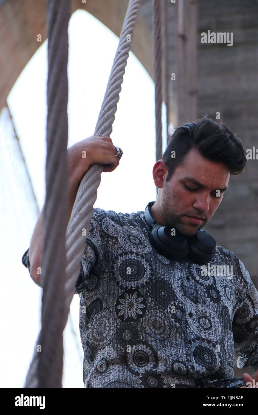 A vertical shot of a man holding a rope in headphones Stock Photo - Alamy