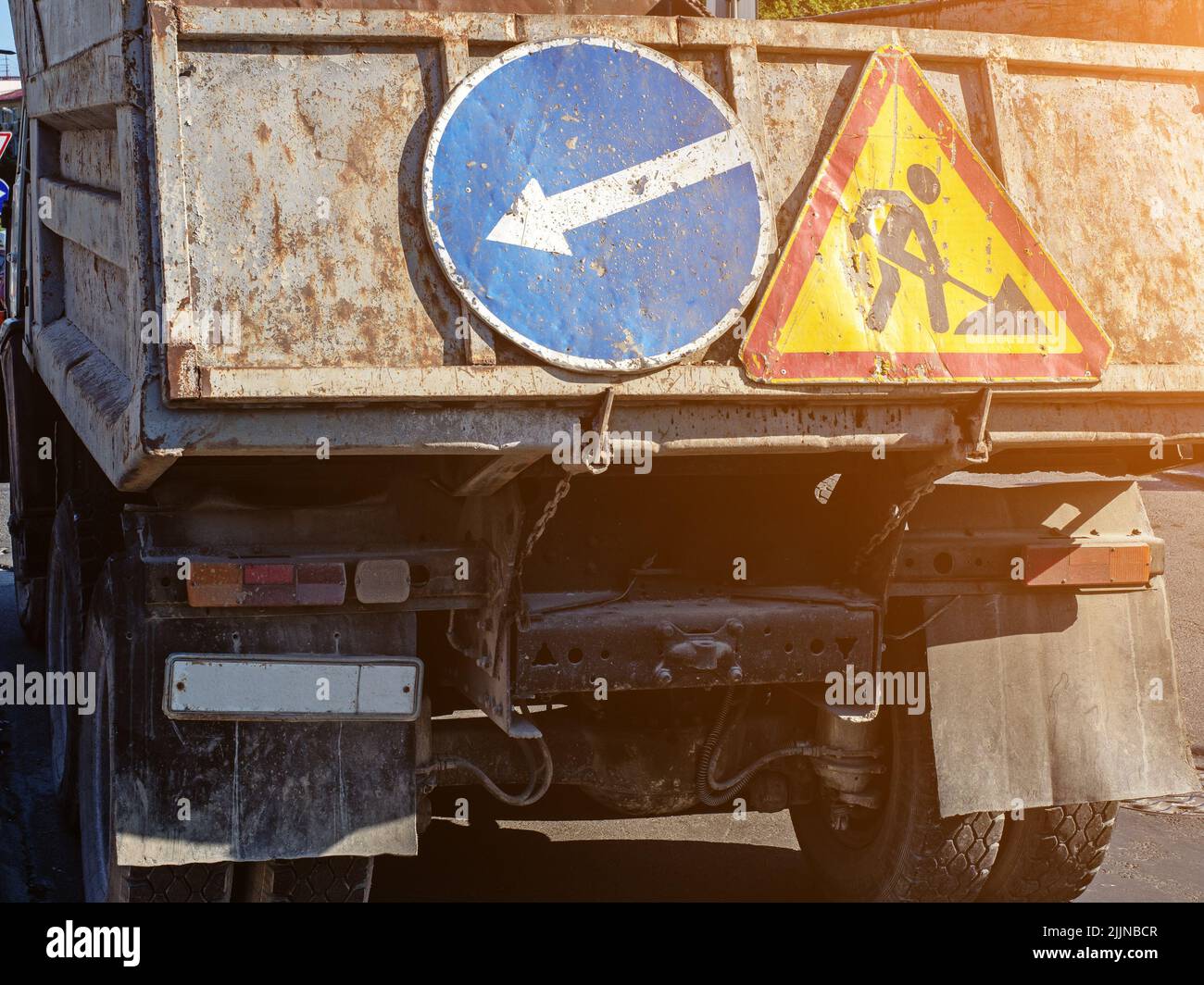 There are warning signs on the back of the truck. Road works in ...