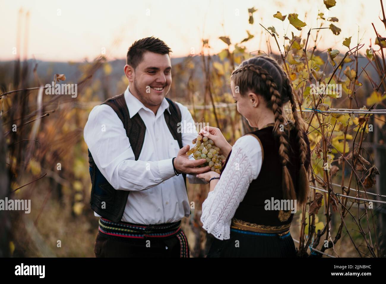A beautiful shot of a Serbian couple in traditional costumes posing for ...
